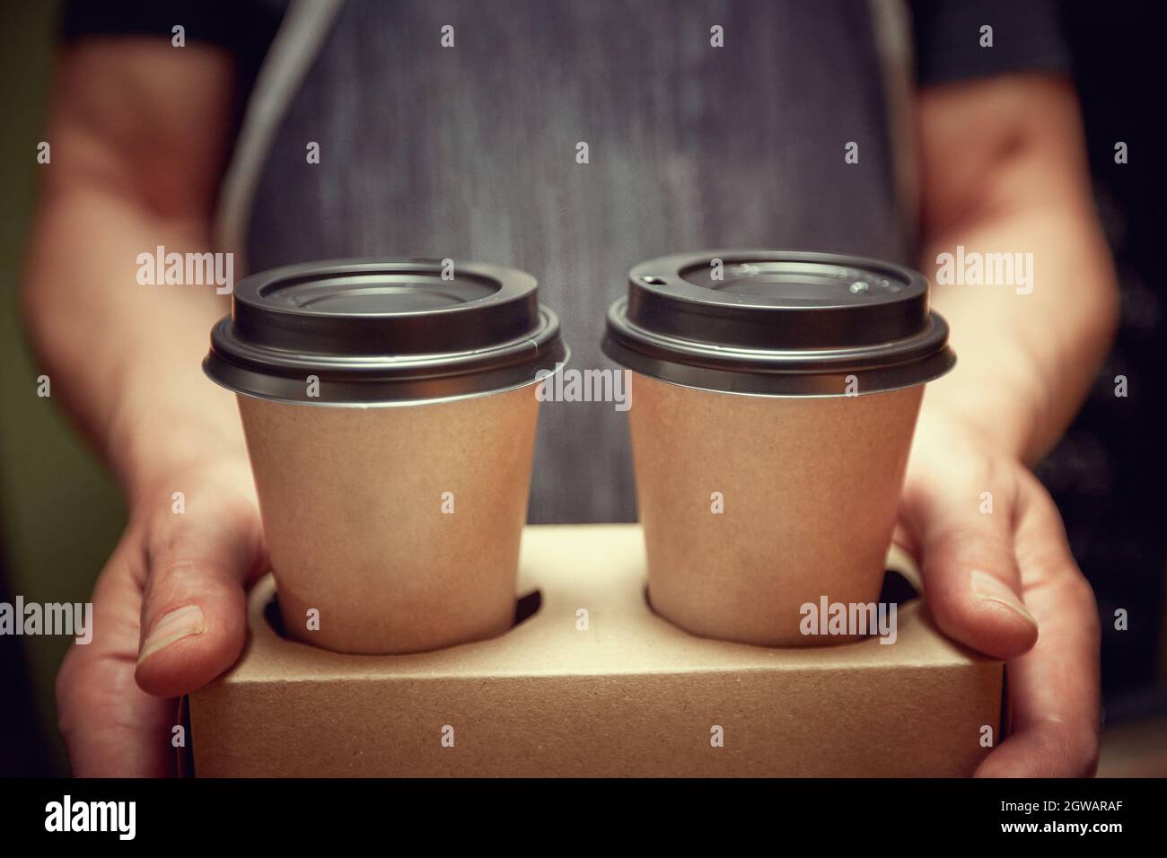 Barista holding and serving cup of fresh dark coffee to go Stock Photo ...
