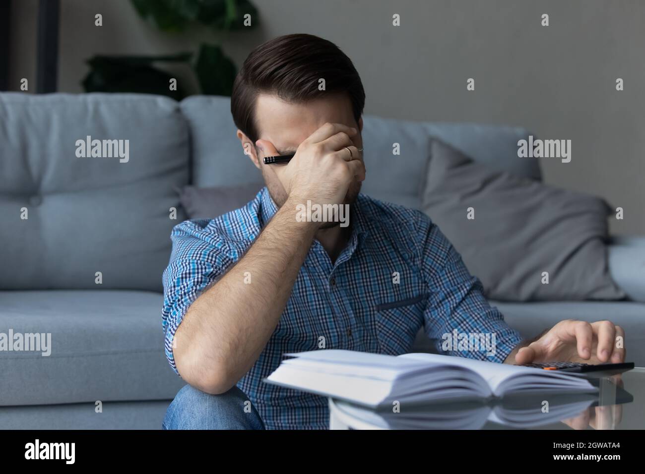 Unhappy man calculating bills, upset by money problem Stock Photo - Alamy
