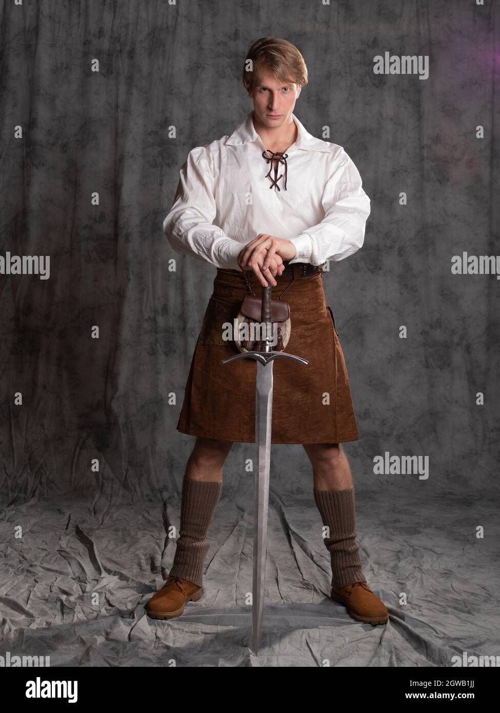A young man in a leather kilt and a white lace-up blouse. A Scottish ...