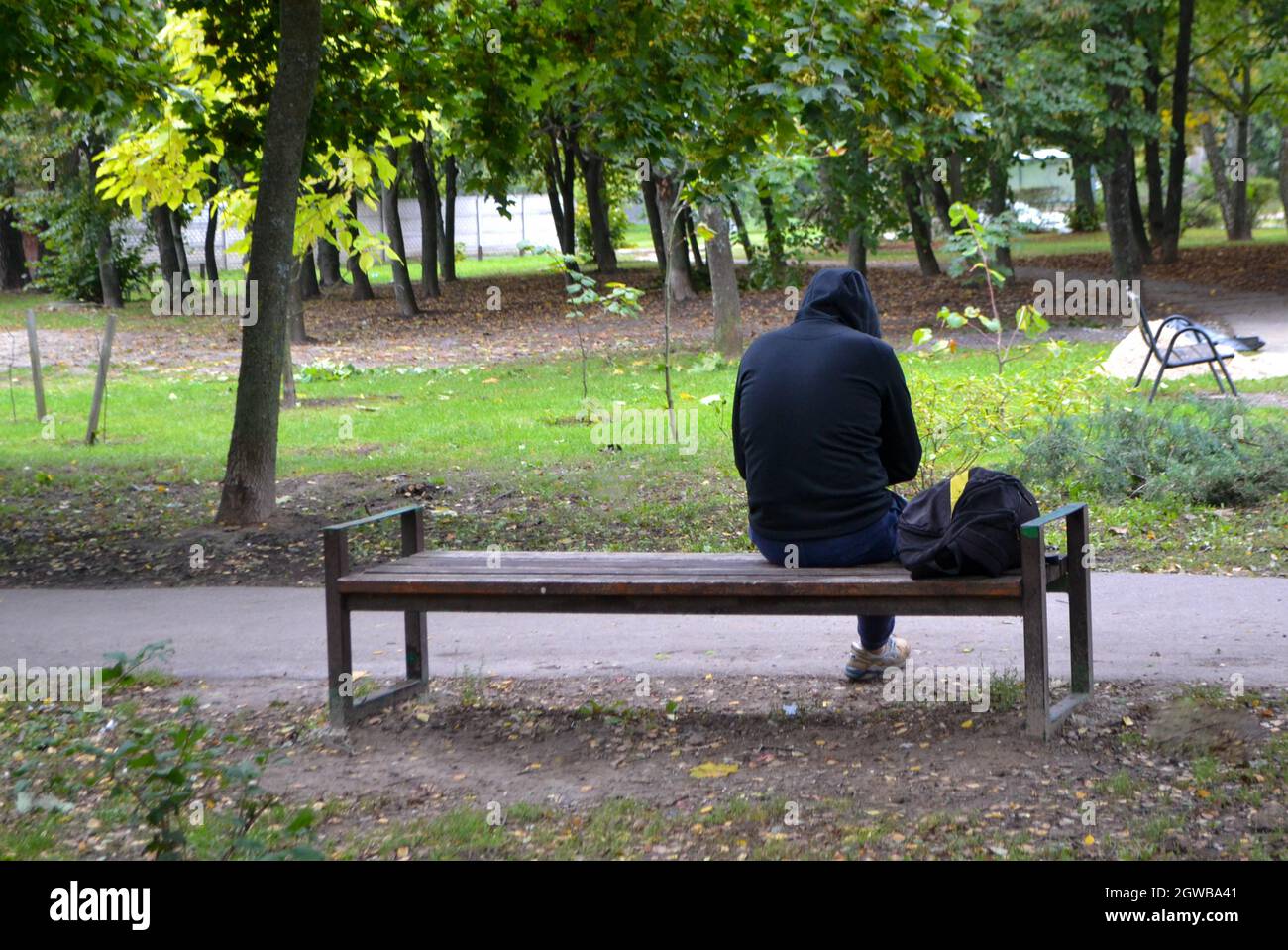 Back of man alone on park bench hi-res stock photography and images - Alamy
