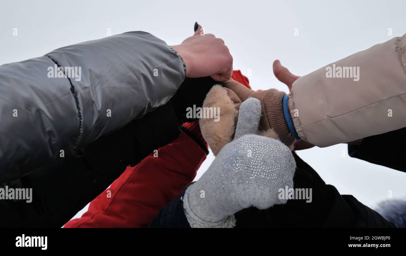 Friends in mittens join their hands and make a thumbs up Stock Photo ...