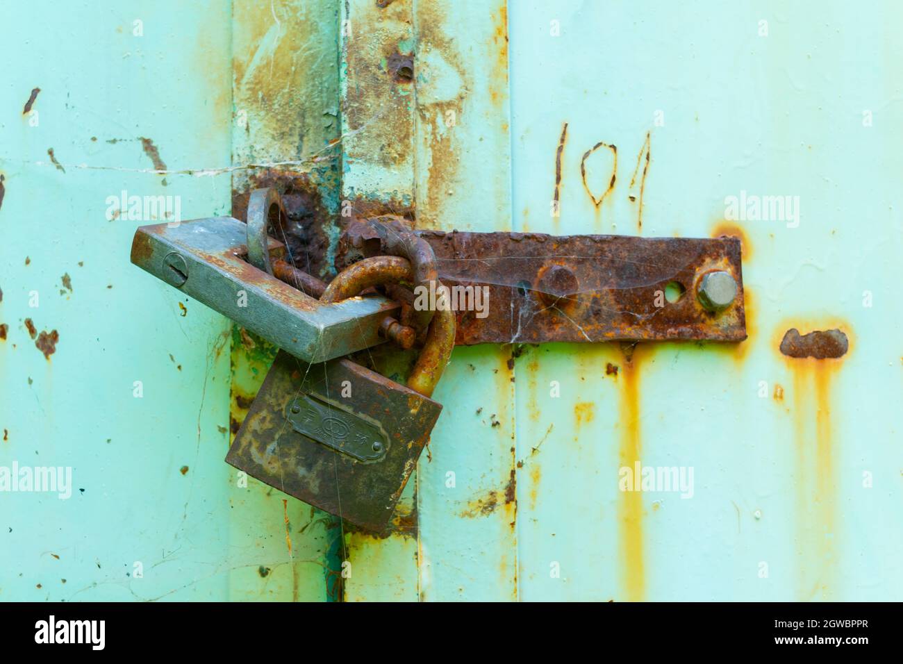 An old rusted padlock on a blue metal door Stock Photo - Alamy