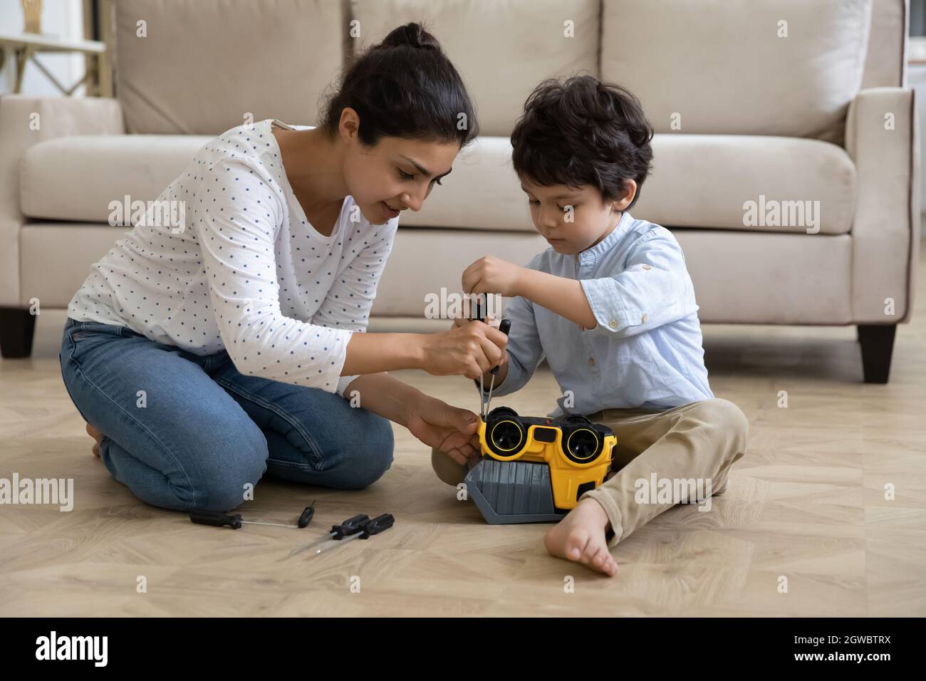 Happy young indian mother fixing toy car with little son Stock Photo ...