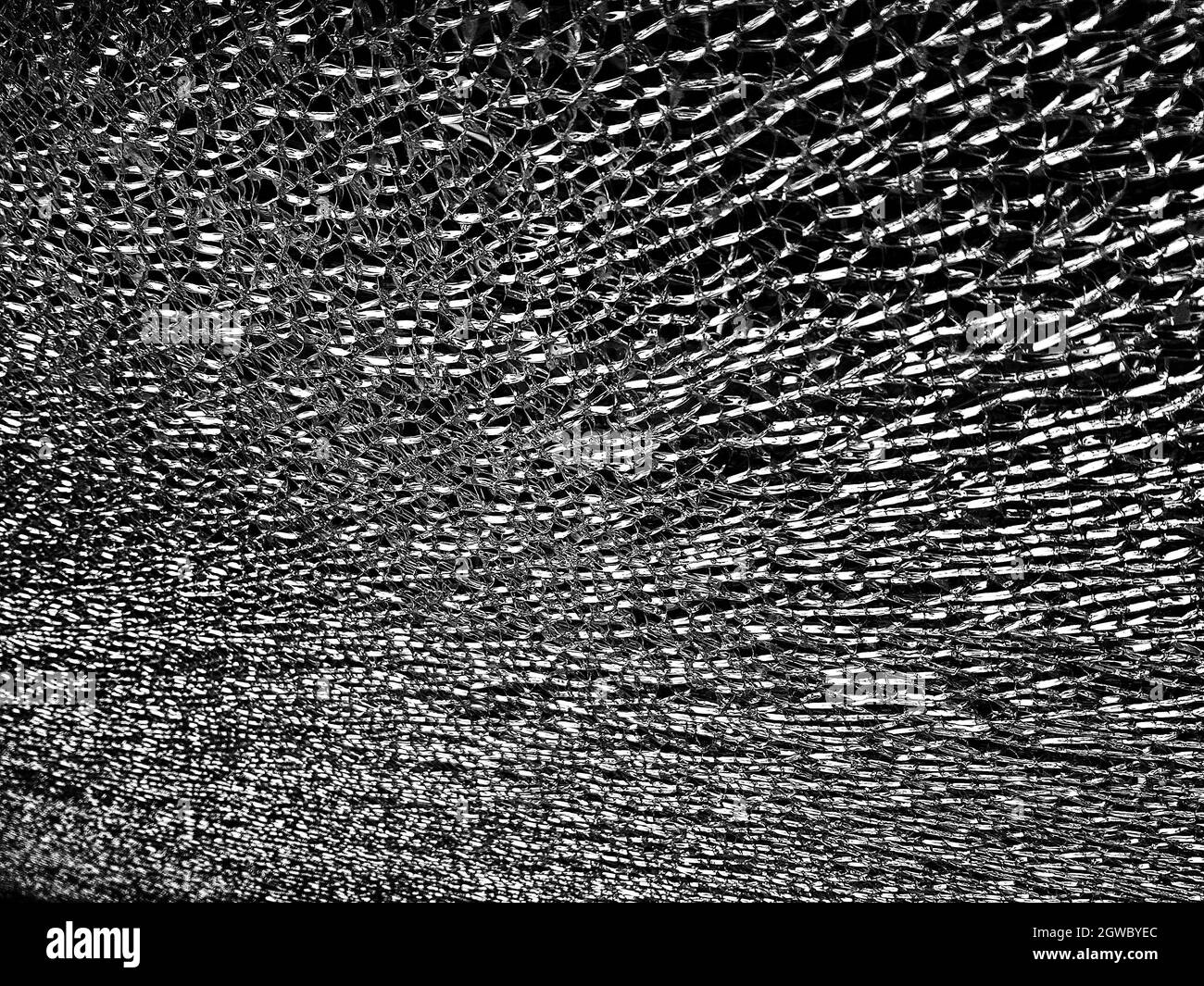 A closeup of a shattered glass texture on a black background Stock ...
