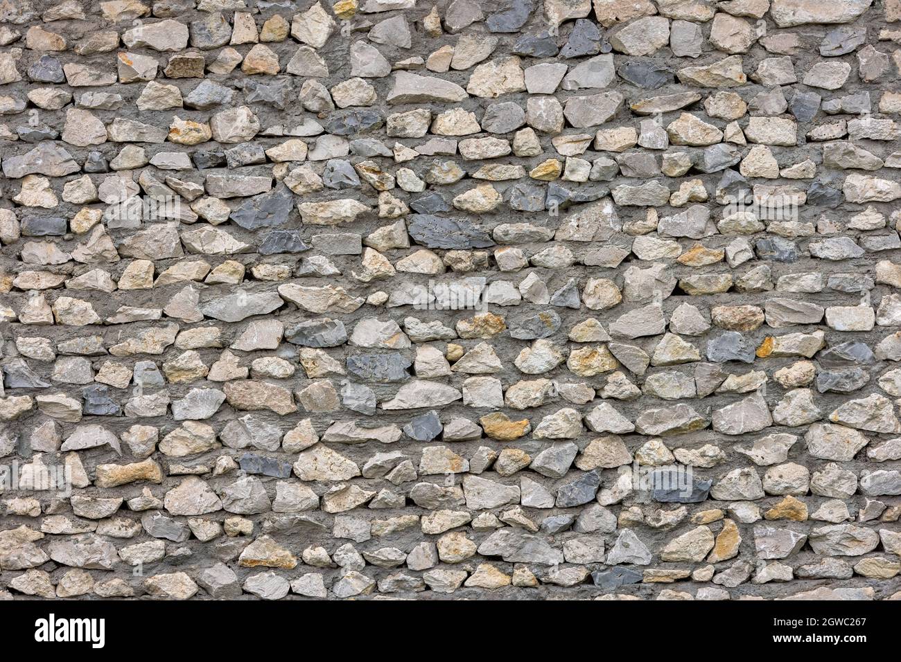 seamless texture of ugly sharp stone wall with concrete between rocks ...