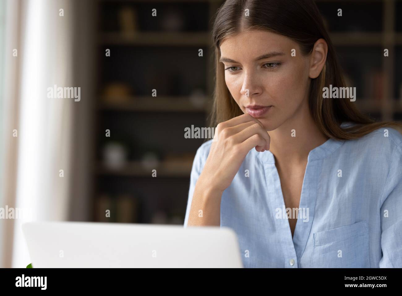 Serious young office worker thinking over work project task Stock Photo ...