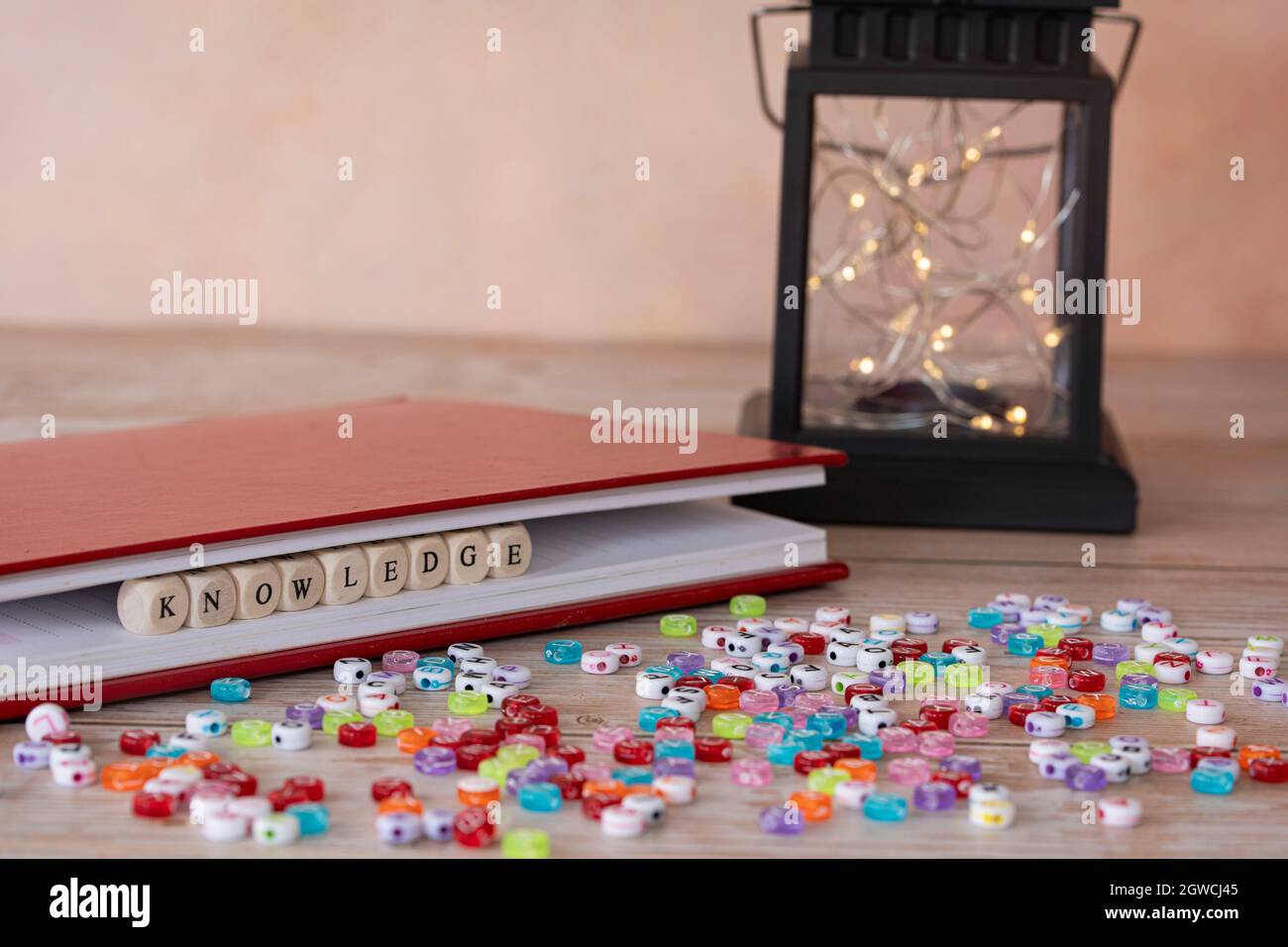 Alphabet blocks spelling KNOWLEDGE between book pages, colourful toy ...