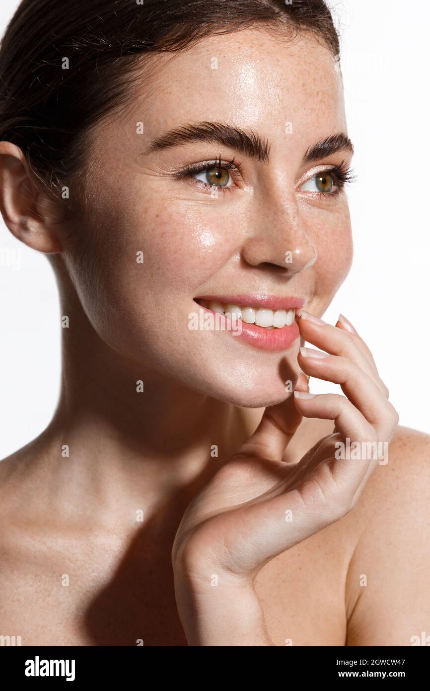 Close up of happy young woman with fresh glowing skin tone, showing ...