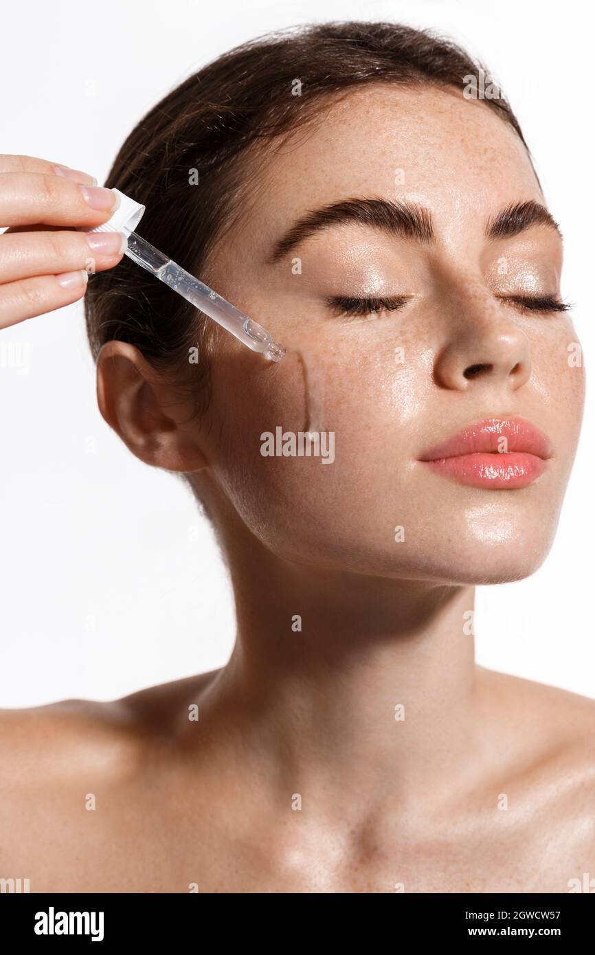 Skin care. Young woman apply moisturizing facial serum, hand holding ...