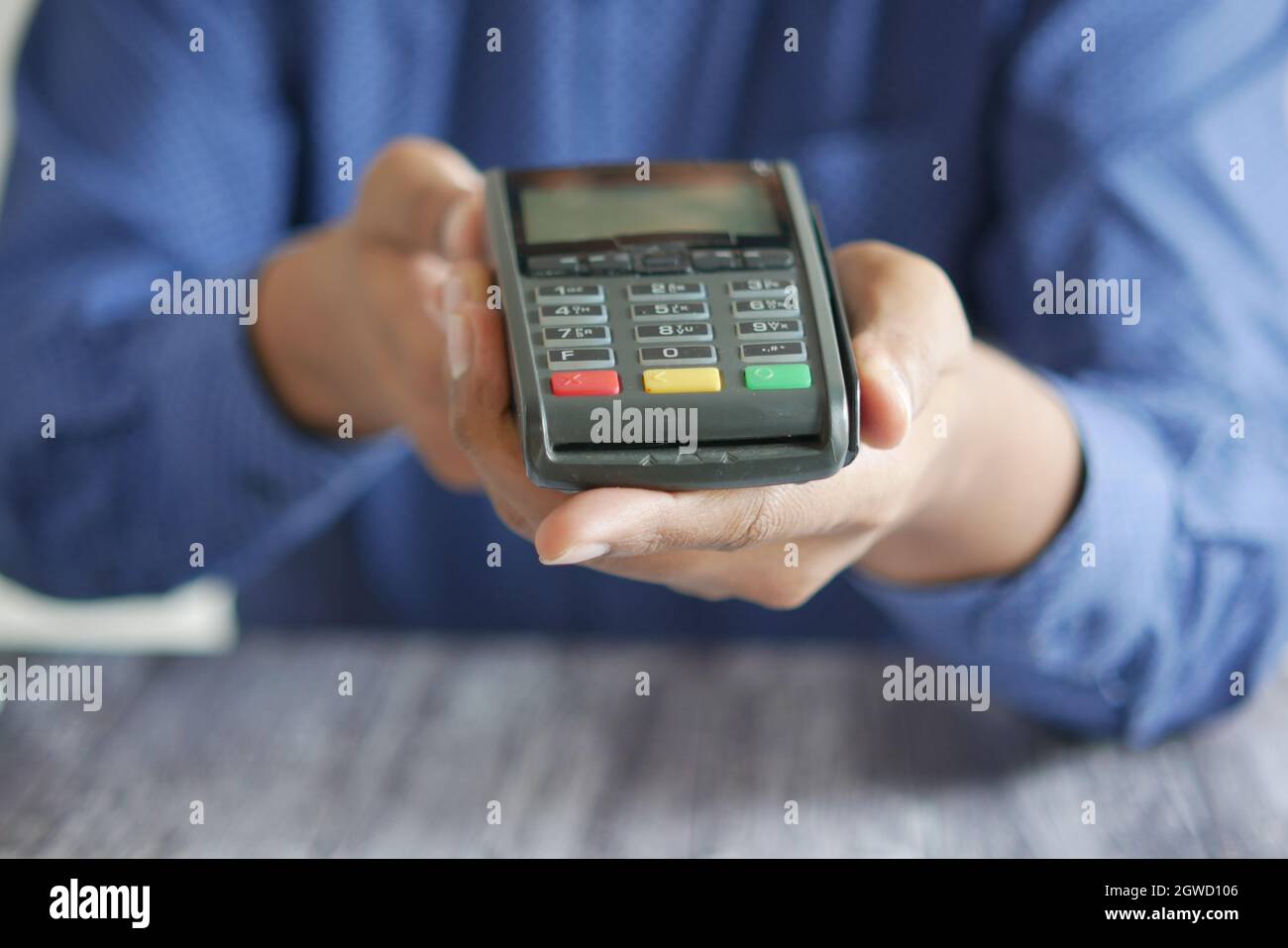 hand holding pos machine close up Stock Photo - Alamy