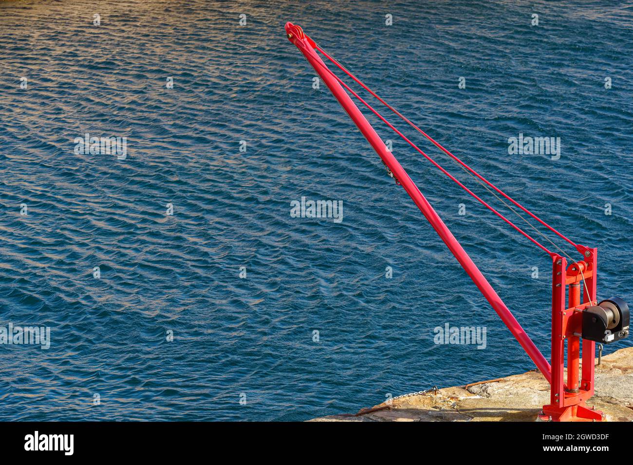 LINDESNES, NORWAY- SEPTEMBER 08. Old red iron crane for lifting up smal ...