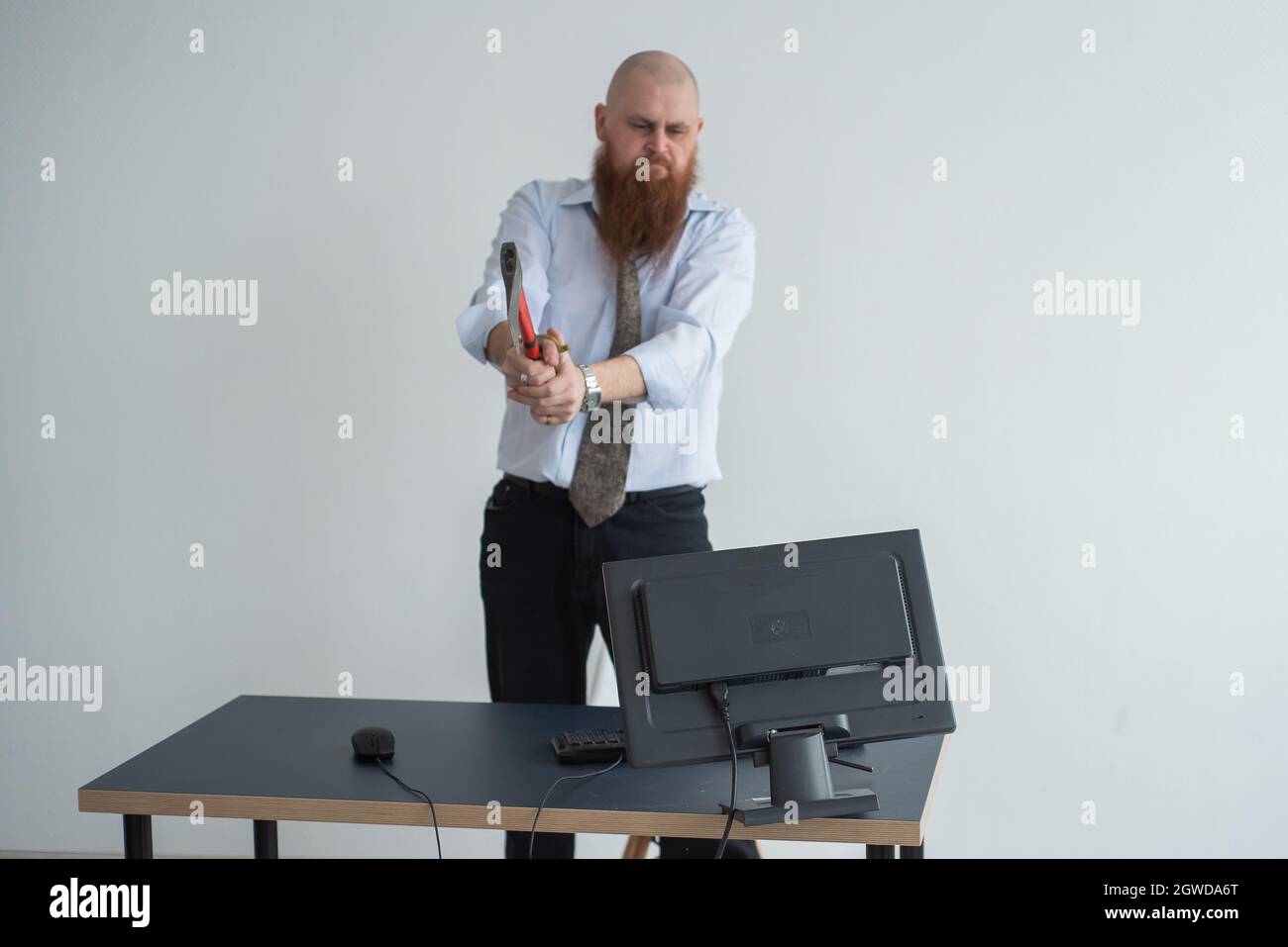 Stressed crazy businessman smashing his computer in office using ax ...