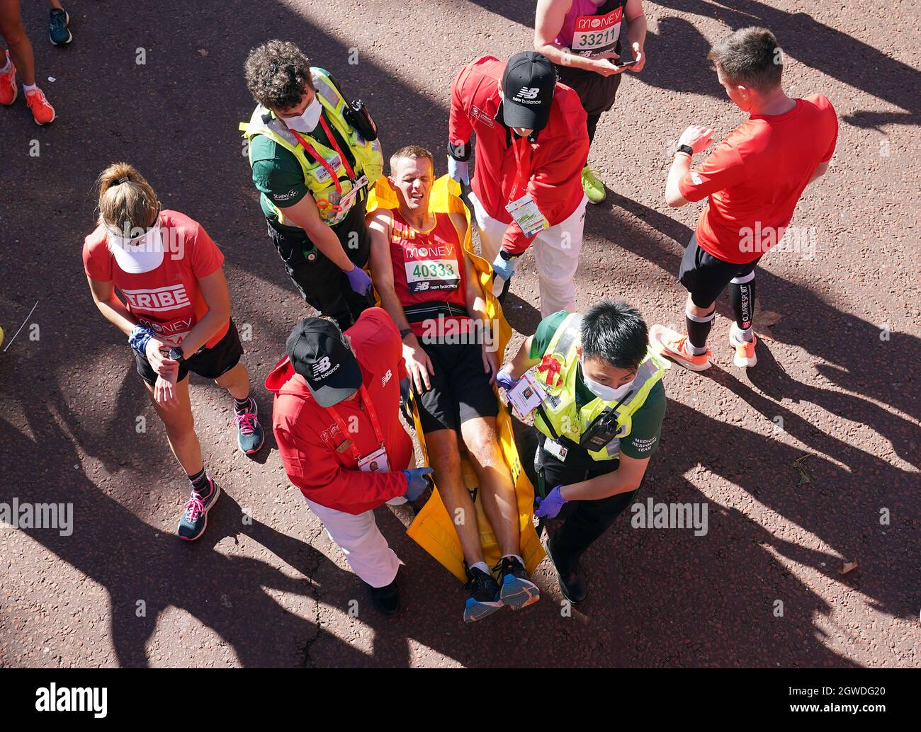 A runner is helped by paramedics after finishing the Virgin Money ...
