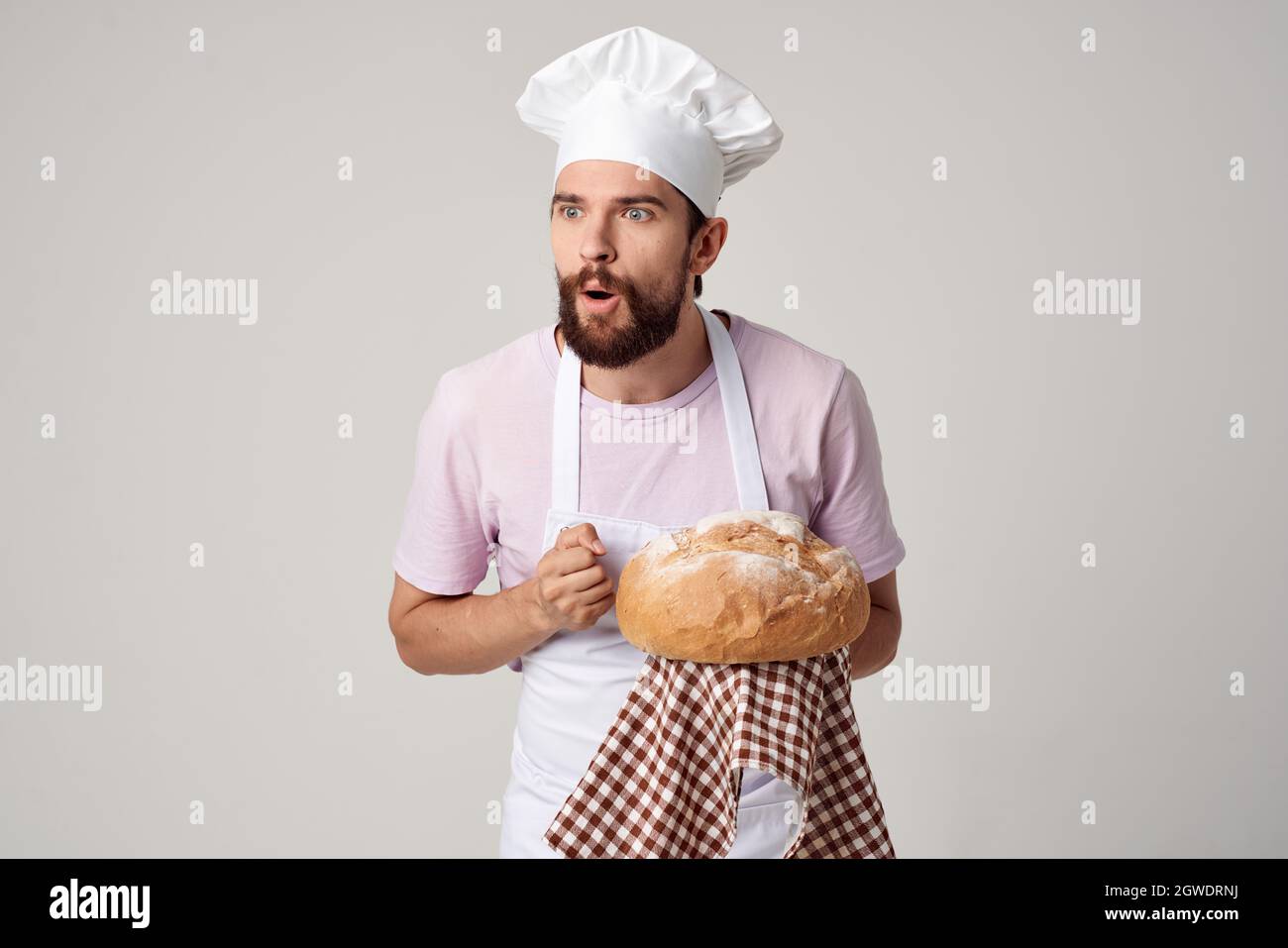 bearded man in white apron baker holding bread in hands Stock Photo - Alamy