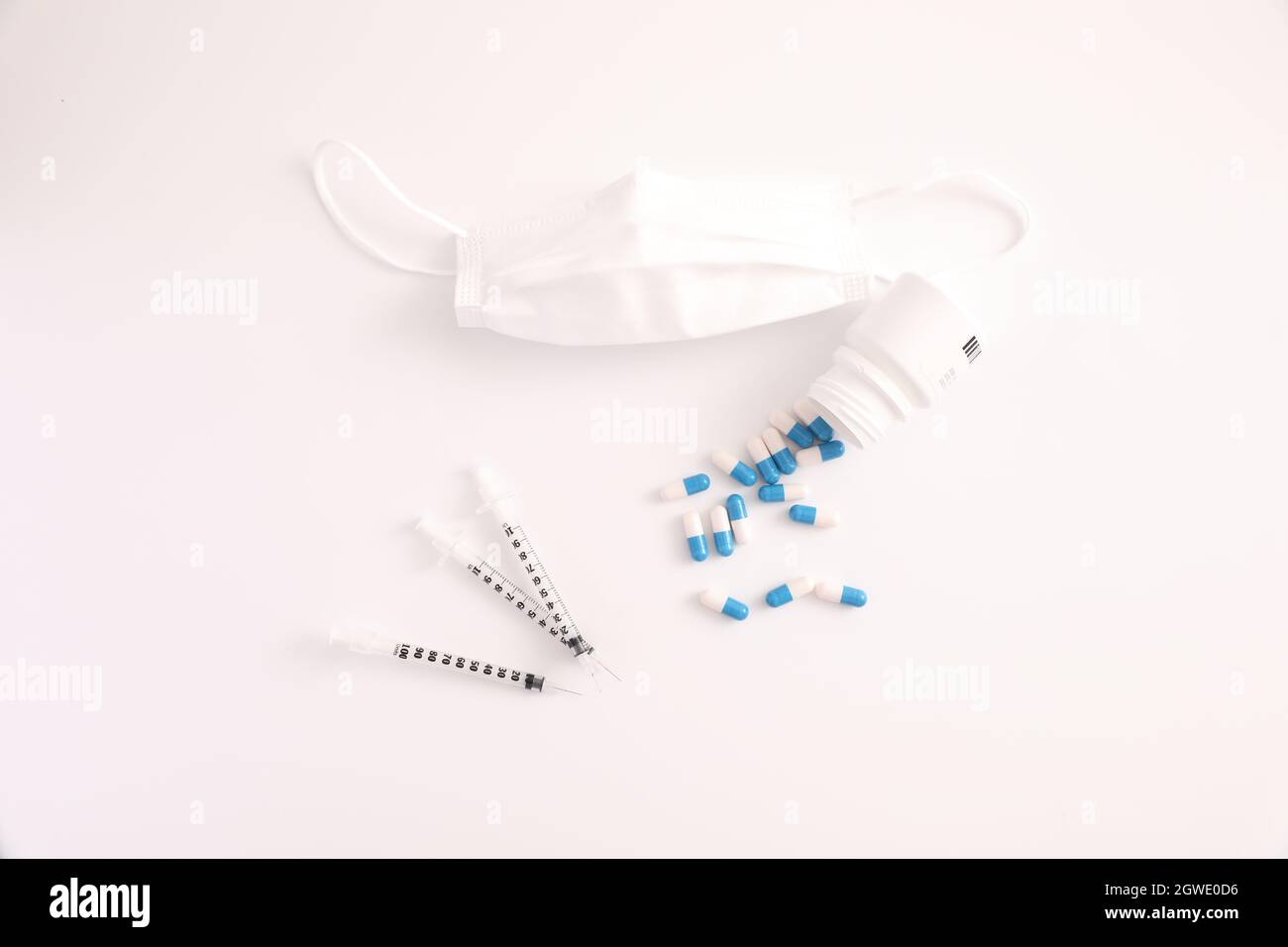 Syringe with pill and mask isolated in white background Stock Photo - Alamy
