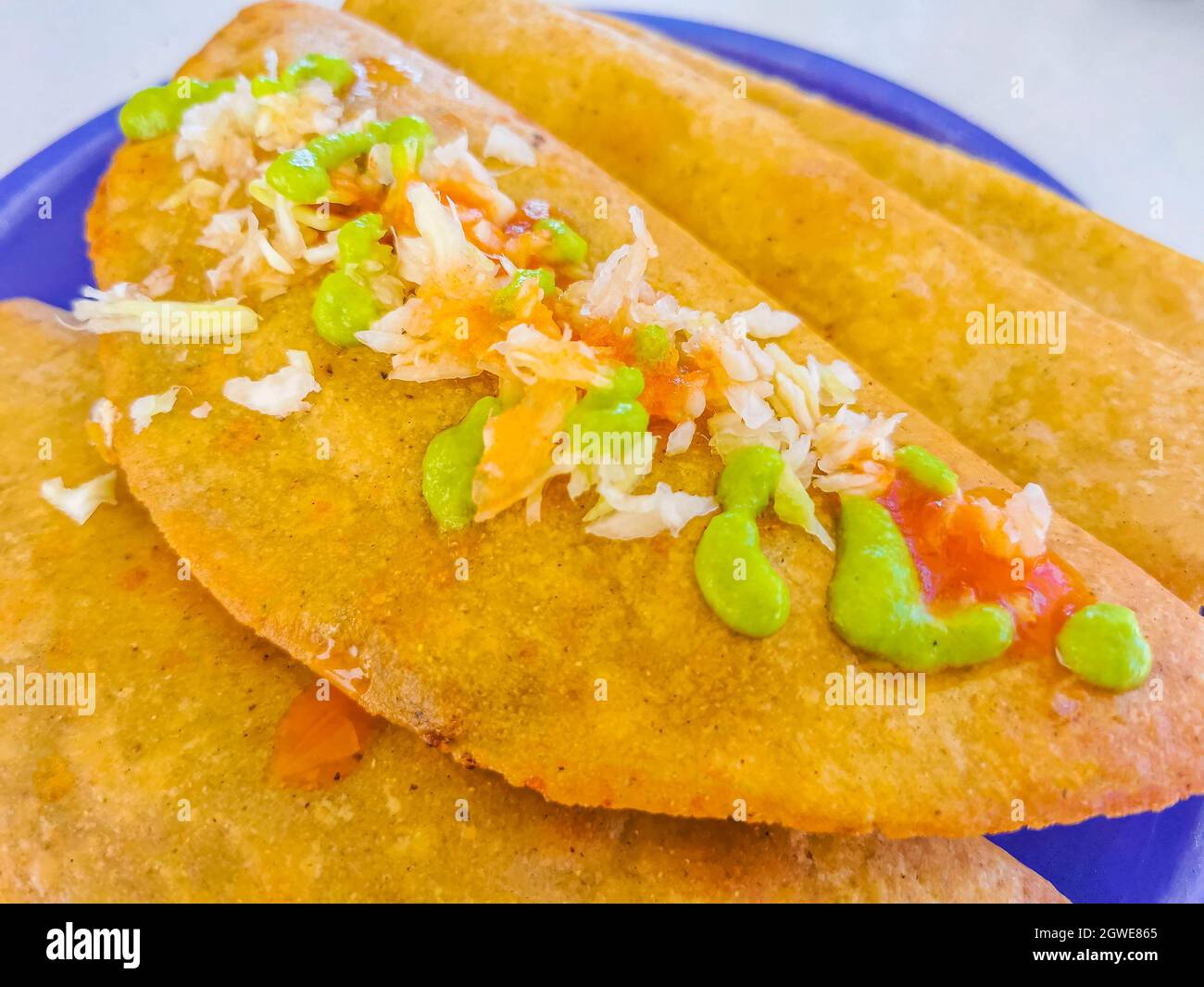 Mexican empanada with cabbage and hot sauce on blue plate white ...