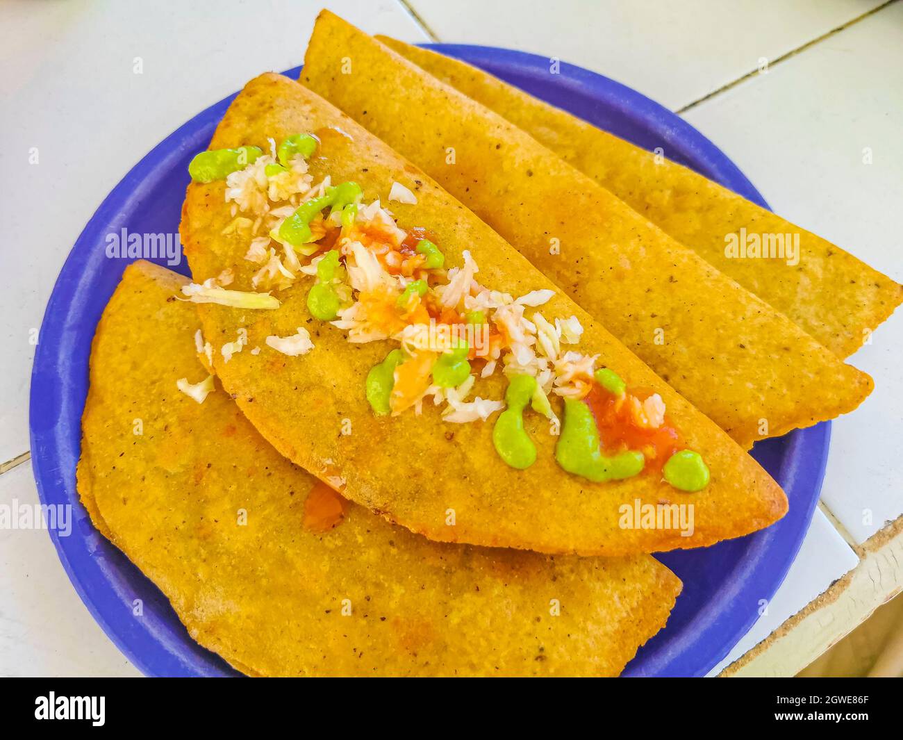Mexican empanada with cabbage and hot sauce on blue plate white ...