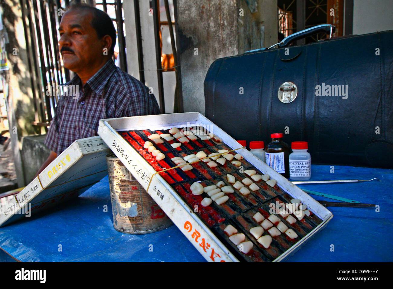 Bangladeshi street dentist displays his replacement teeth in a street ...