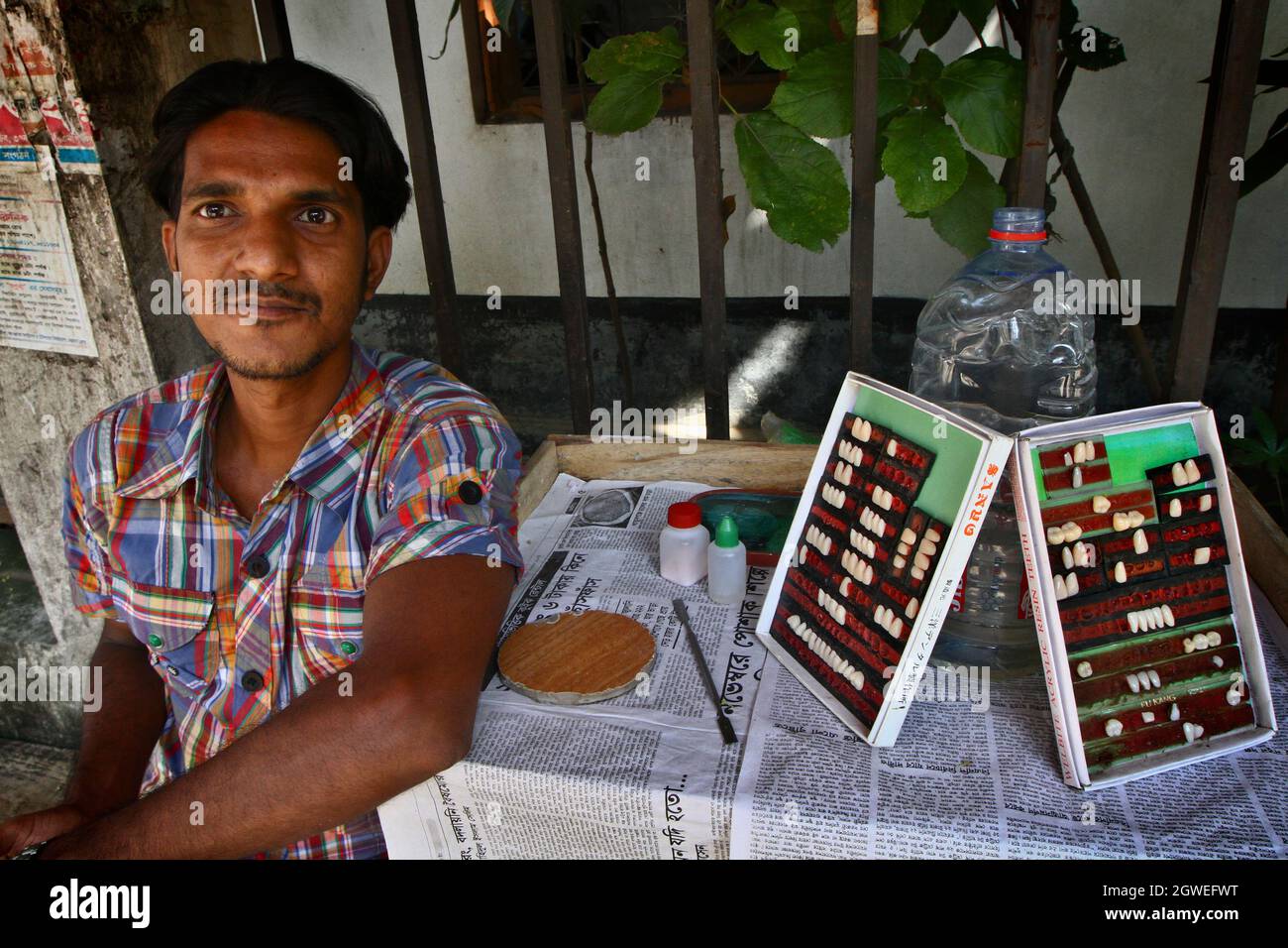 Bangladeshi street dentist displays his replacement teeth in a street ...