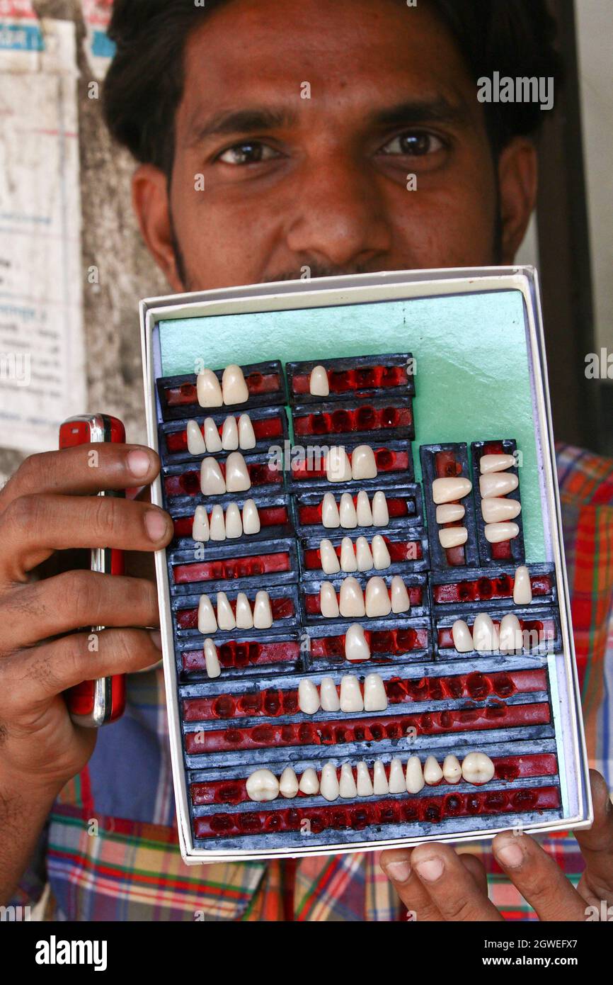 Bangladeshi street dentist displays his replacement teeth in a street ...
