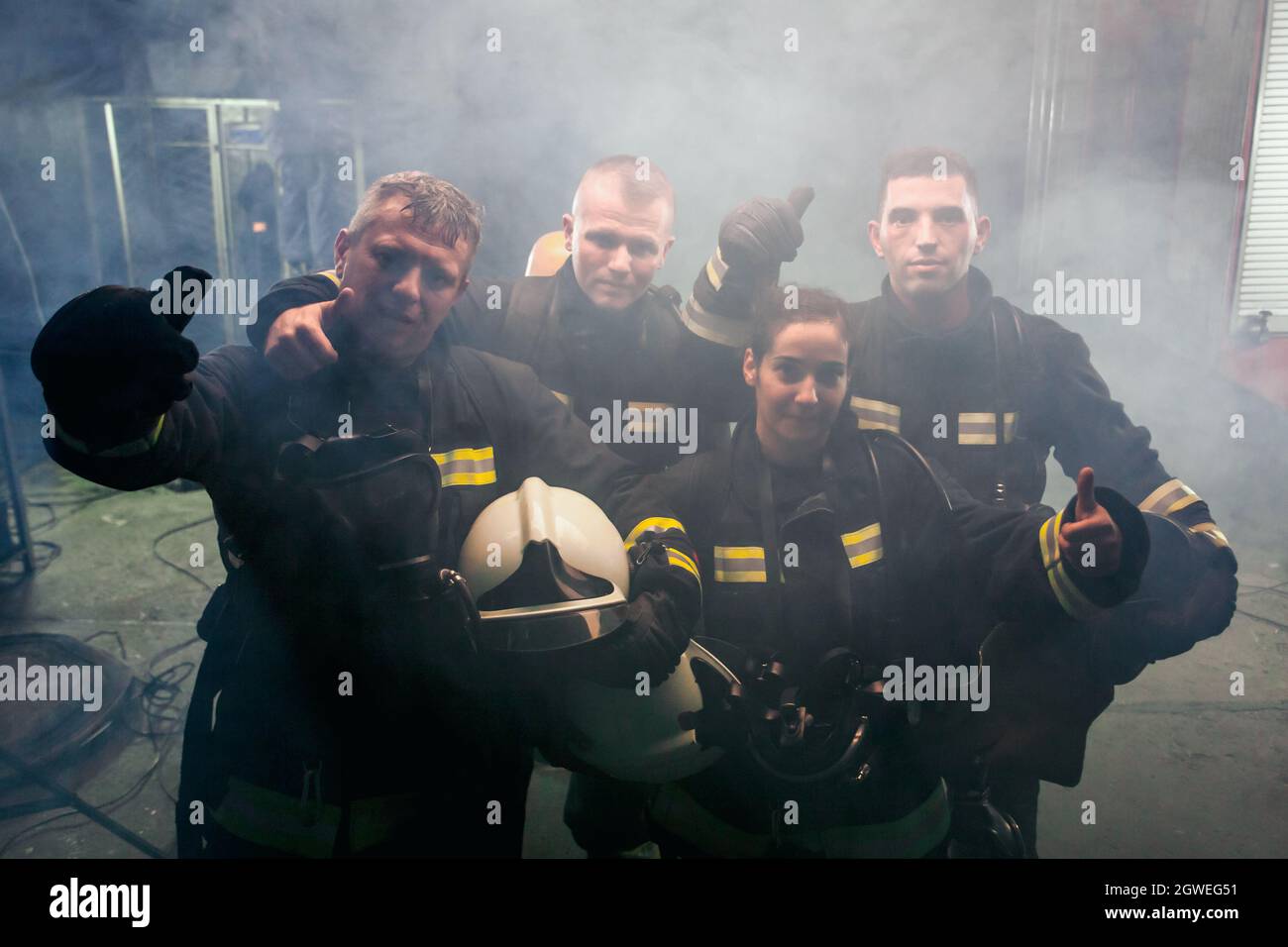 Group of professional firefighters wearing full equipment. relaxed ...