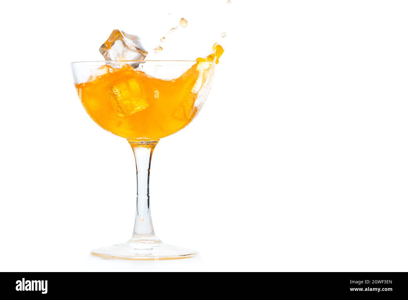 Drop ice cubes in to orange soda in Margarita glass isolated on white background, summer ...