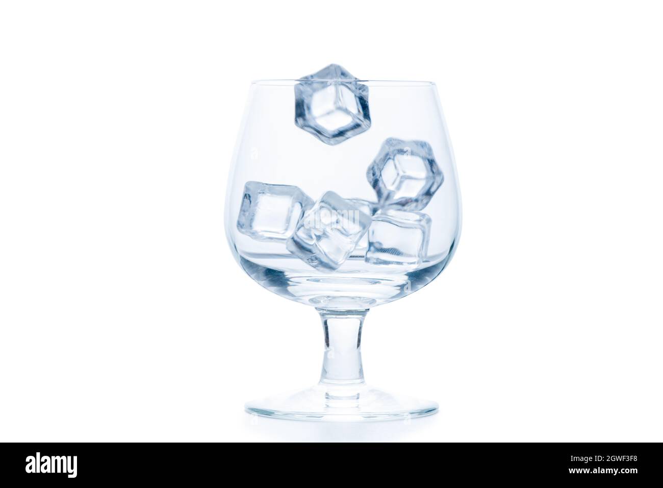 drop ice cubes in to empty Snifter or Balloon glass isolated on white ...