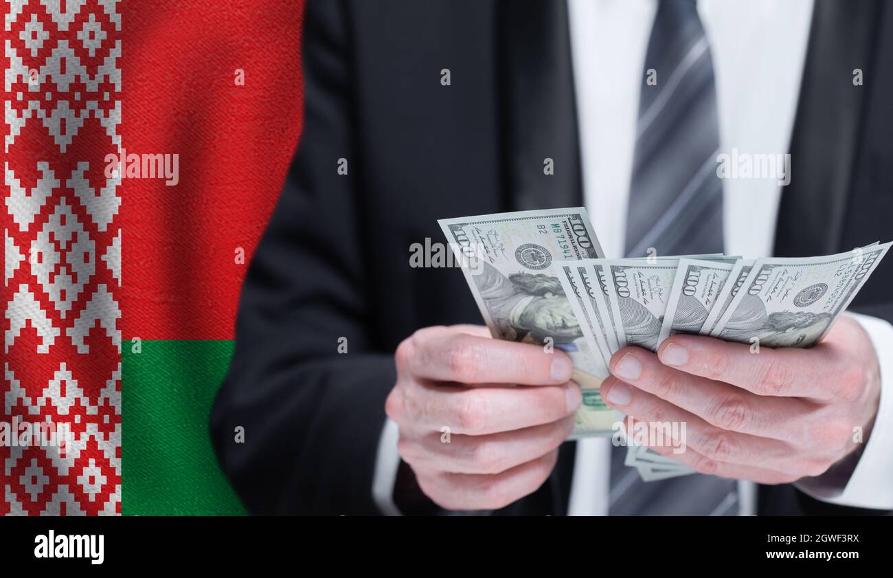 Hands holding dollar money on flag of Belarus Stock Photo - Alamy