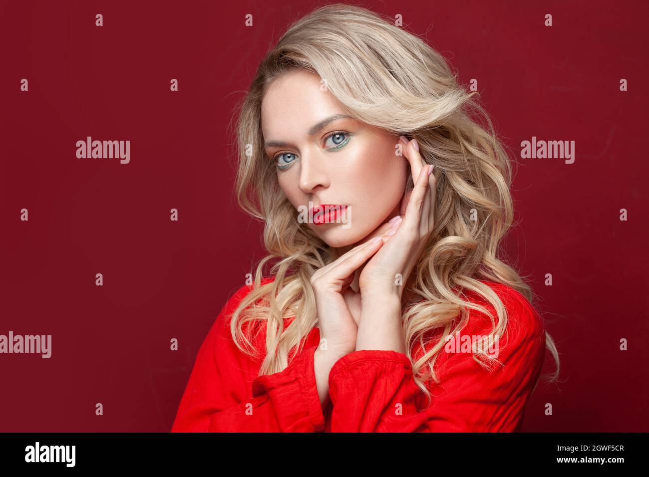 Stylish female model blonde woman. Beautiful face on red background ...