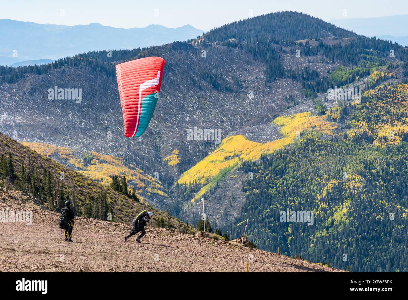 A paraglider pilot runs to launch his paraglider off the top of Monroe ...
