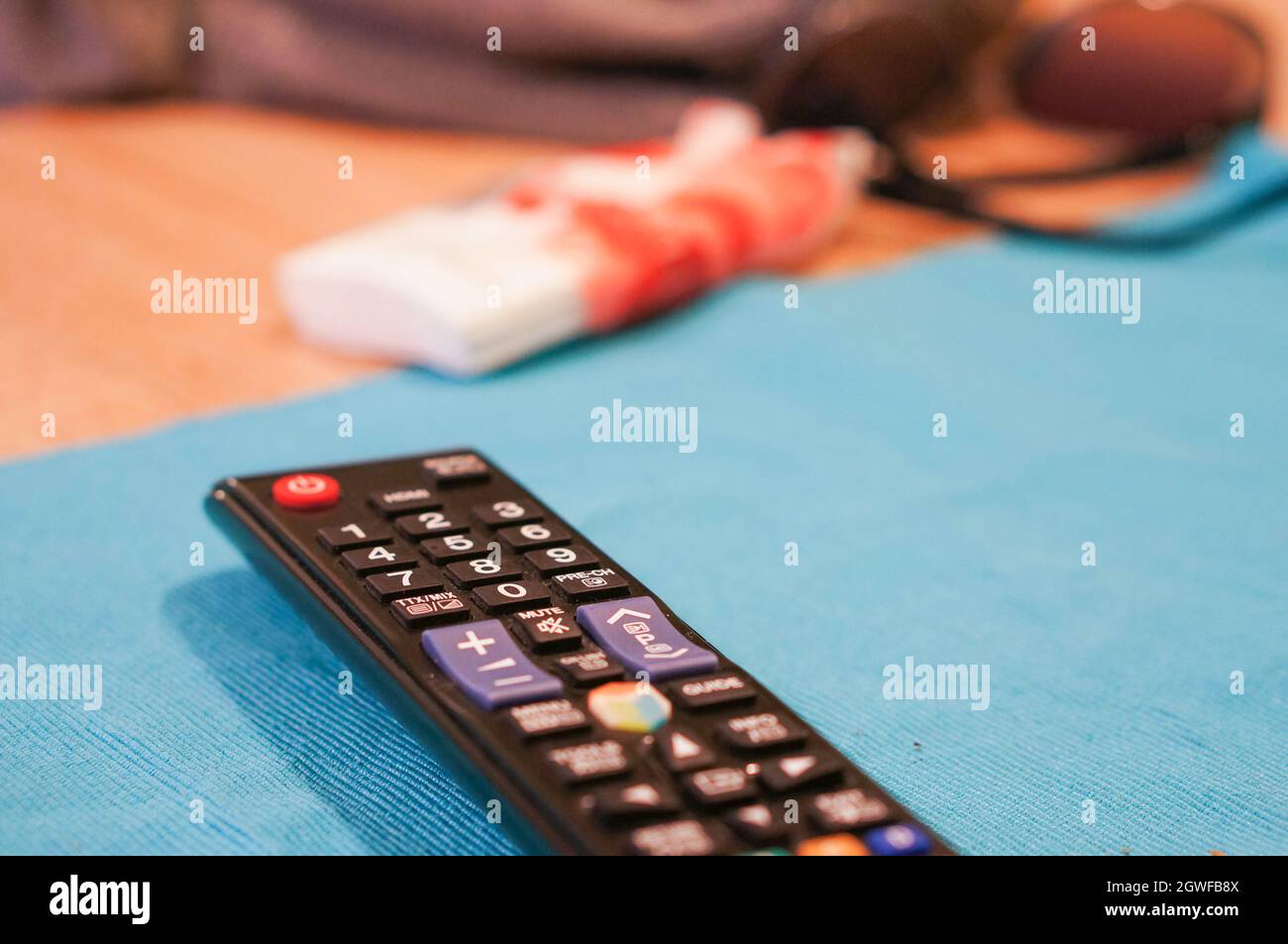 A television remote lying on the blue table cloth Stock Photo - Alamy