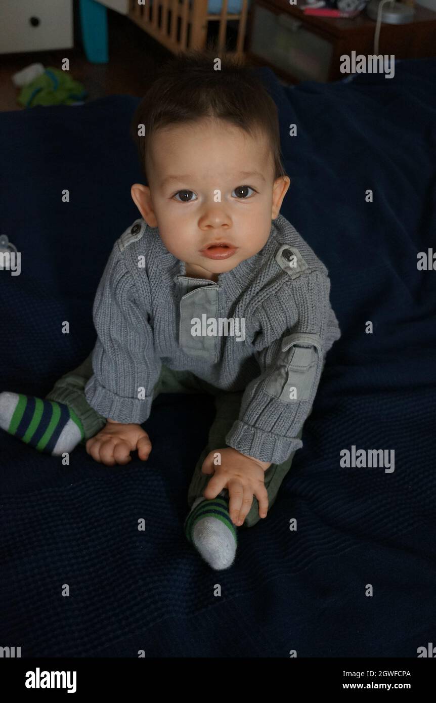 A vertical closeup shot of a cute little Caucasian male baby with a ...