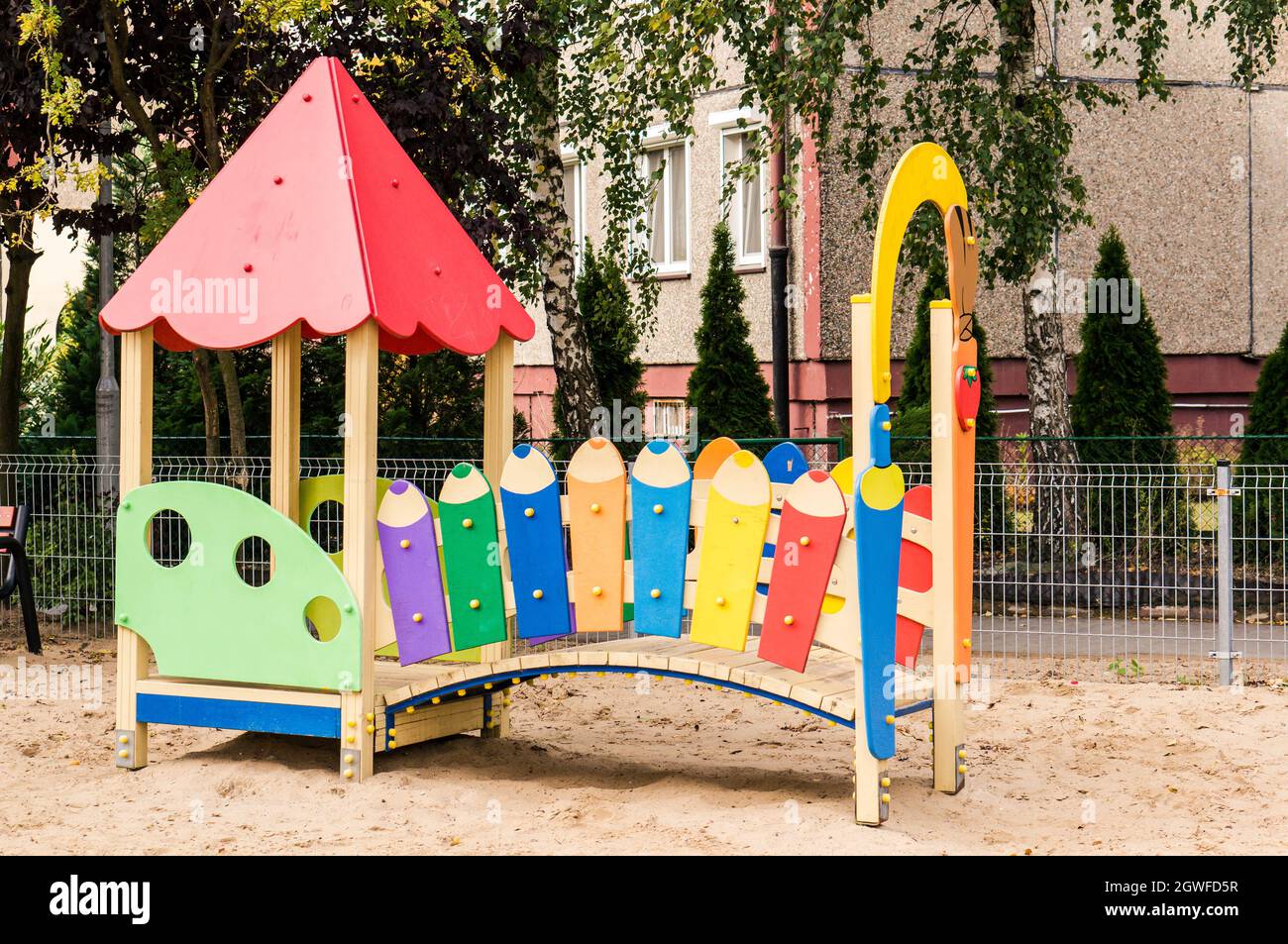 The colorful equipment with stairs and slides on a sandy playground in ...