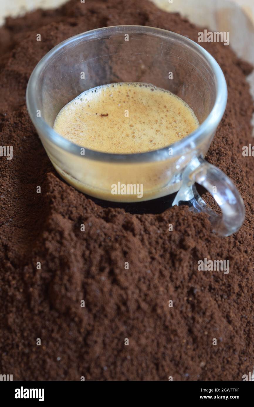 restricted espresso dipped in ground coffee Stock Photo - Alamy