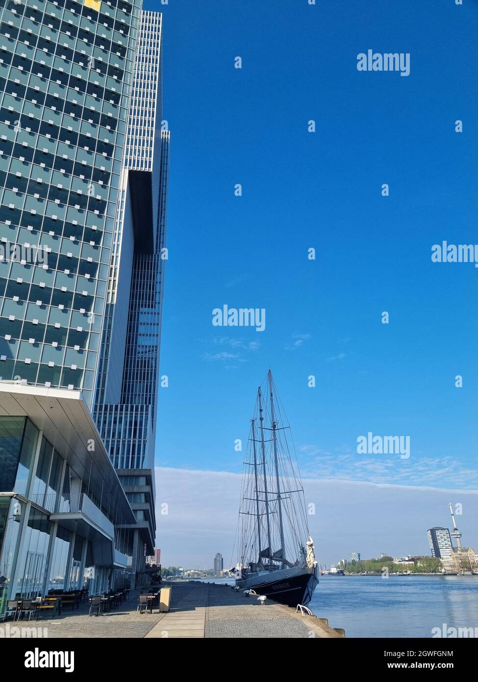 Modern building and sailing mast against blue sky in Rotterdam Stock ...