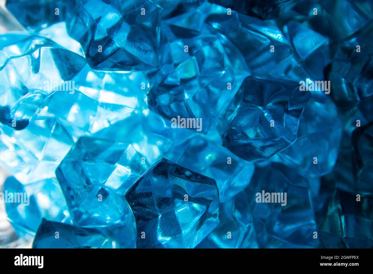 Bright blue crystals made of glass look like gems close-up in the blur ...