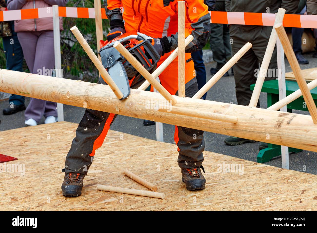 A worker demonstrates the skill of using a chainsaw at the working site ...