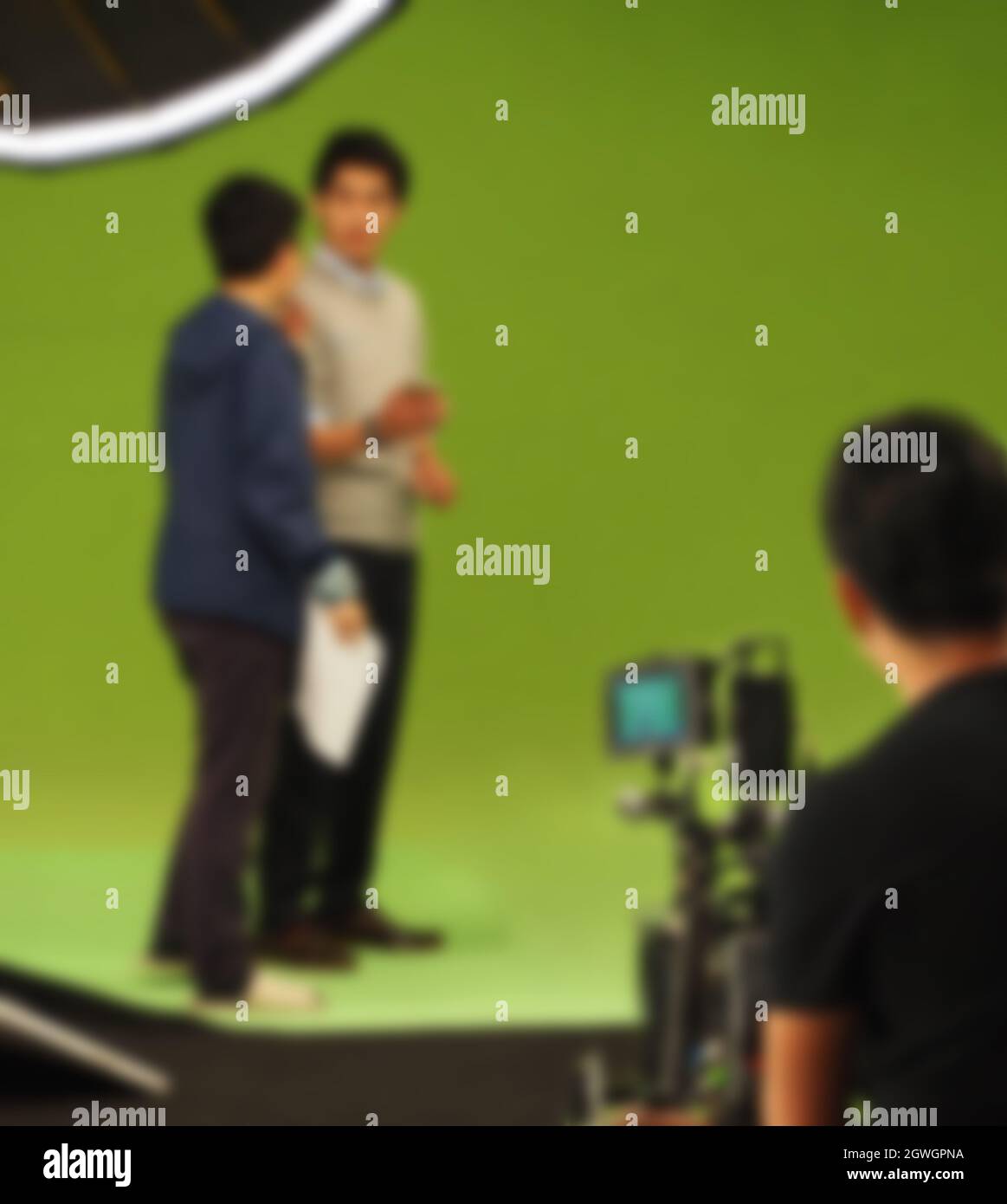 Blurry images of making TV commercial movie video in big green screen ...