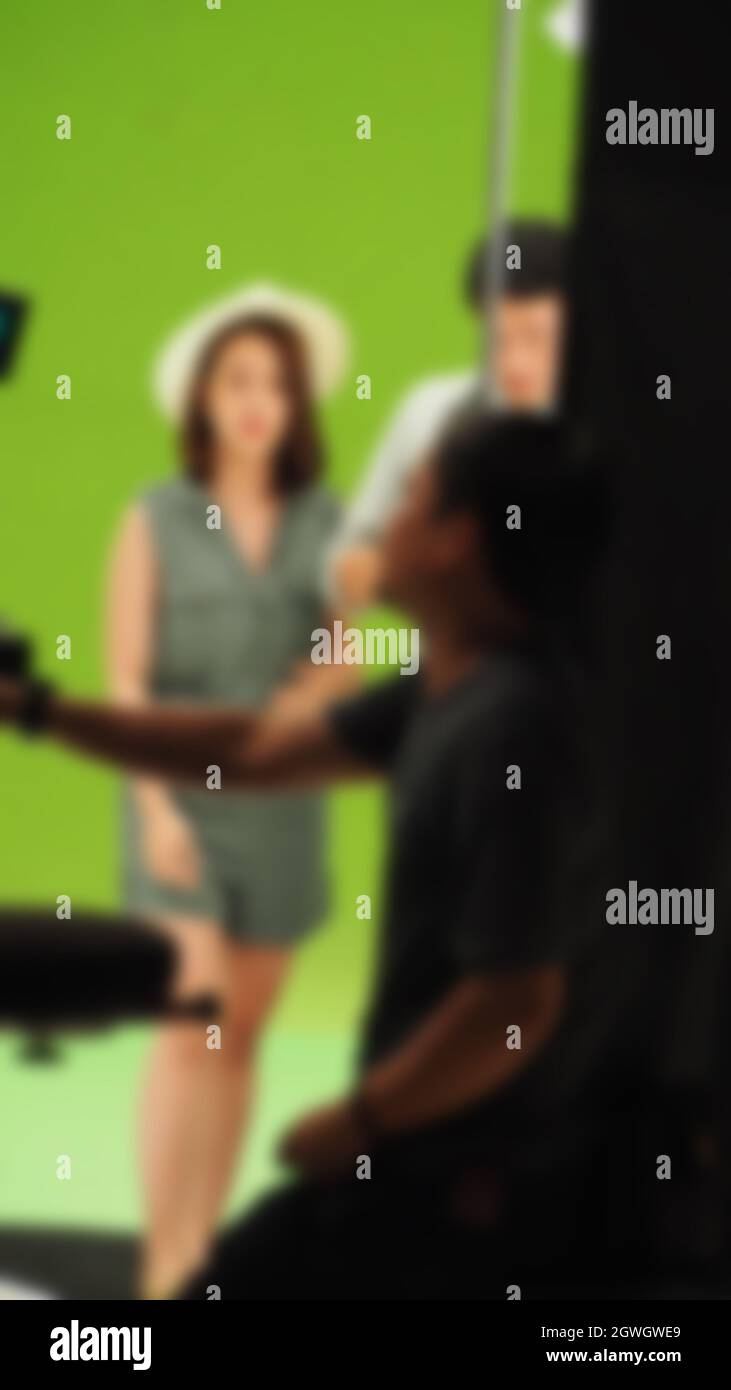Blurry images of making TV commercial movie video in big green screen ...
