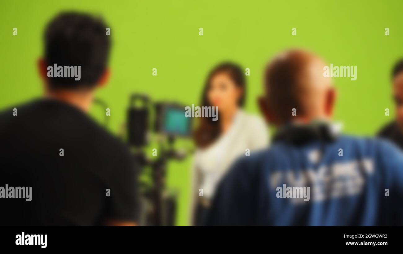 Blurry images of making TV commercial movie video in big green screen ...