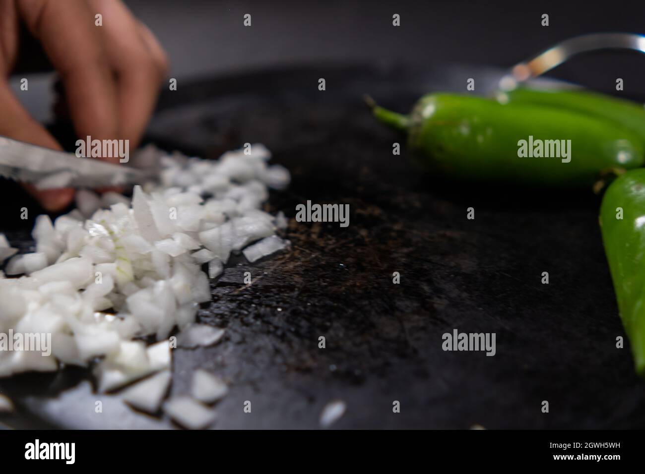 Hands chopping onion and green chili peppers on a traditional Mexican ...