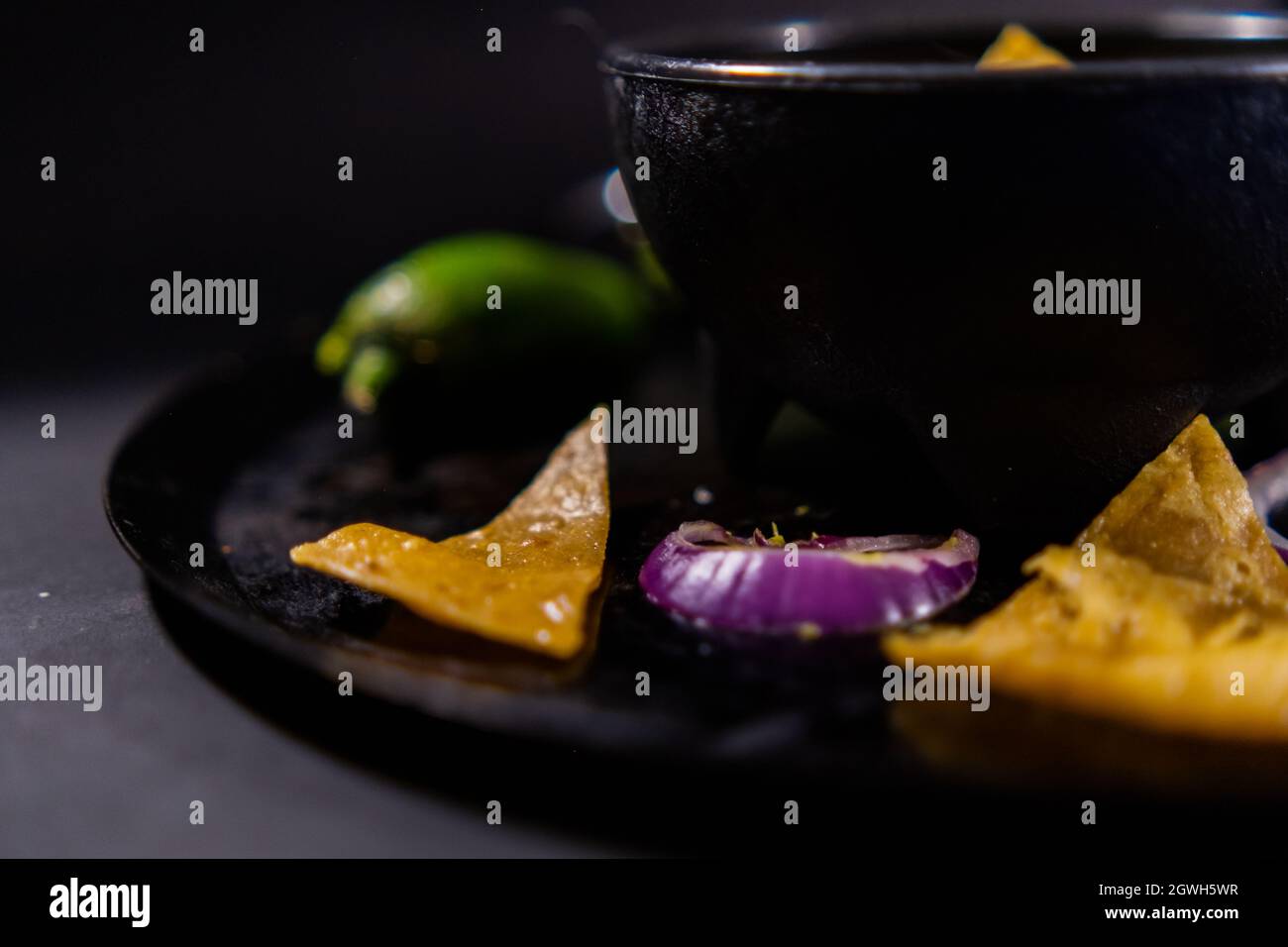 Tortilla chips, chili peppers, and onion slices on Mexican comal Stock ...