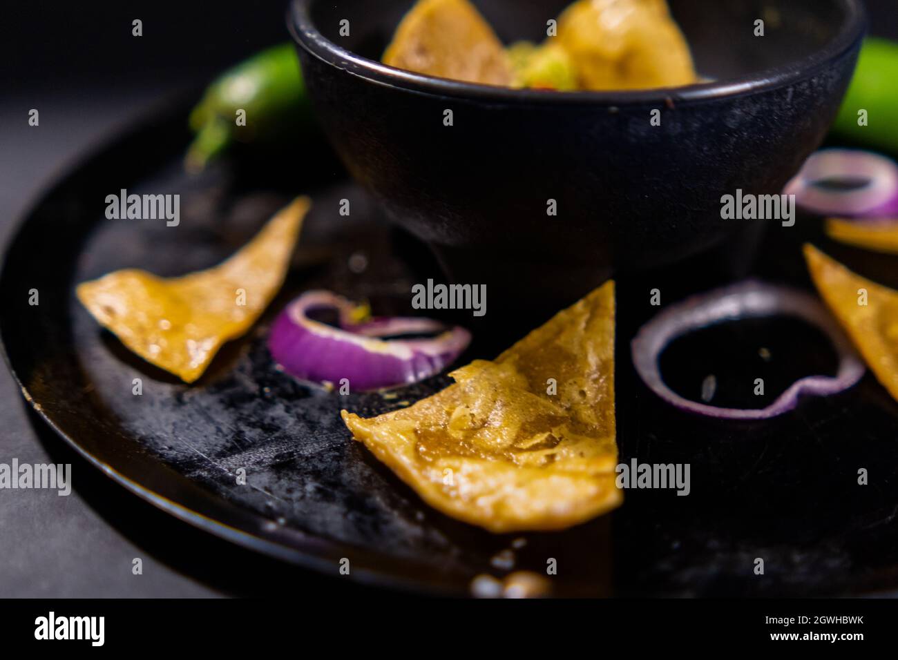 Tortilla chips, chili peppers, and onion slices on Mexican comal Stock ...