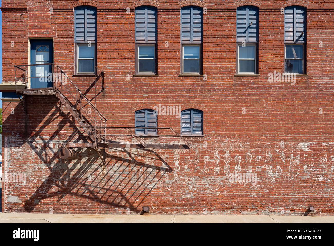 Exterior of old brick building with rusted fire escape Stock Photo - Alamy