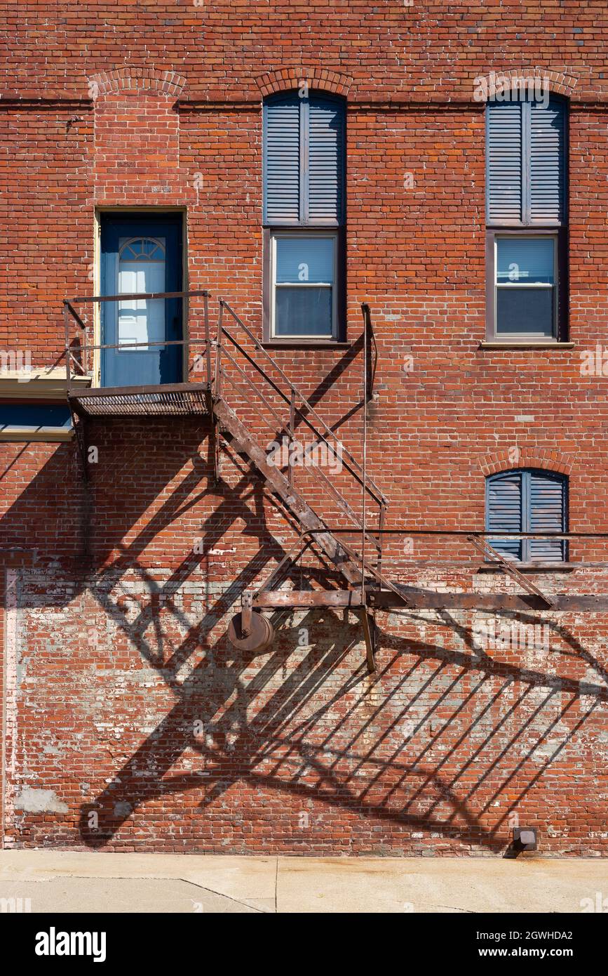 Exterior of old brick building with rusted fire escape Stock Photo - Alamy