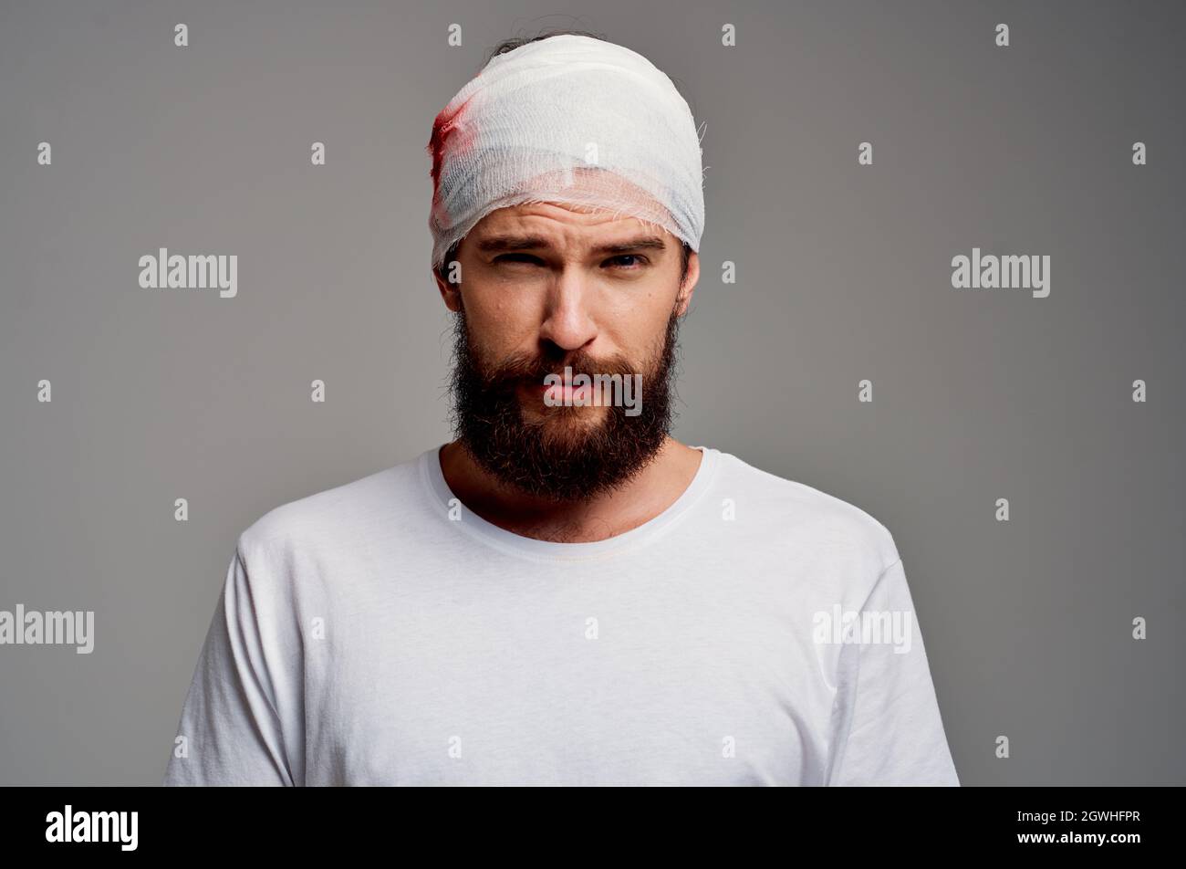 Man bandaged head and hand blood light background Stock Photo - Alamy