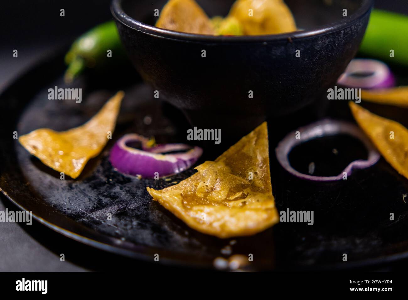 Tortilla chips, chili peppers, and onion slices on Mexican comal Stock ...