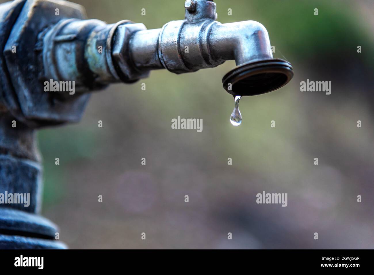 Drop of water falling from a poorly closed tap Stock Photo - Alamy