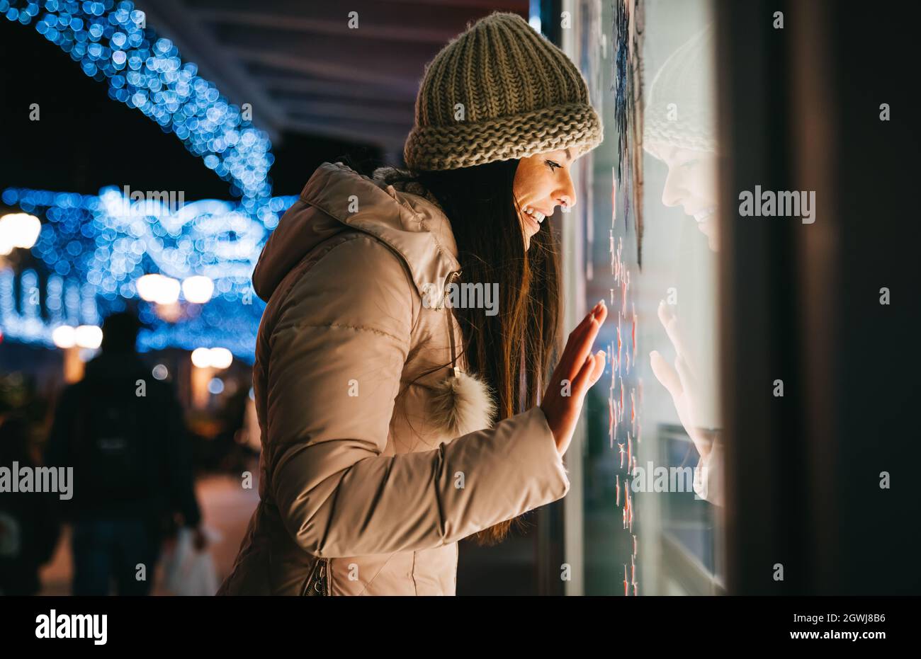 Portrait of a young woman looking at the shop window. Shopping people ...