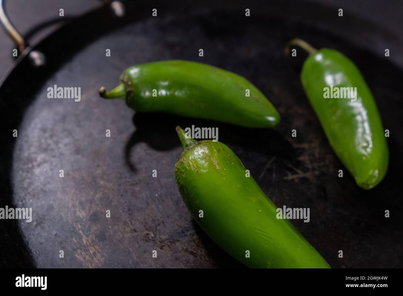 Green chili peppers on a traditional Mexican comal Stock Photo - Alamy